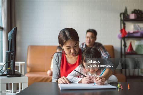 아시아 어머니 가르치는 그녀의 딸 그림 와 연필 동안 아버지 보고 Tv 에 거실 35 39세에 대한 스톡 사진 및 기타 이미지