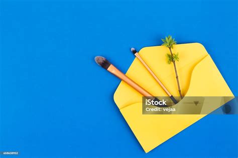 봄 부드러운 나뭇잎과 파란 배경에 노란 봉투에 작은 나무 나뭇가지에 꽃 봉 오리와 브러쉬 메이크업 개인 장식품에 대한 스톡 사진 및 기타 이미지 Istock