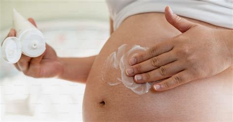 행복한 임산부는 튼살을 방지하기 위해 임신한 배에 스킨케어 크림 로션을 바릅니다 건강한 피부 마사지 트리트먼트와 수분 관리