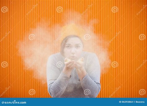 Teenager Blowing A Colored Dust Cloud On An Orange Background Stock
