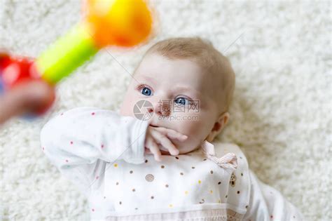 可爱的新生婴儿在白色背景上玩五颜六色的拨浪鼓玩具高清图片下载 正版图片505198734 摄图网