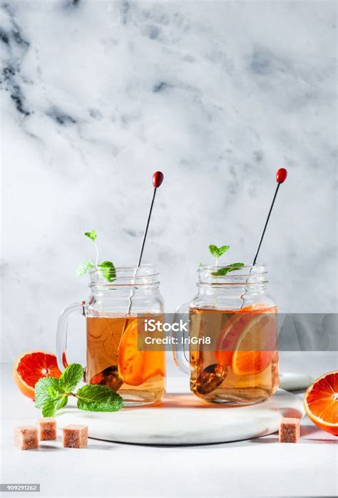 전통적인 아이스 차 전통 차 오렌지와 민트와 메이슨 항아리에 얼음 아이스 오렌지와 민트와 메이슨 항아리에 얼음 백색 대리석