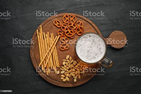 검은 테이블에 맛있는 프레첼 크래커와 다른 간식과 함께 제공되는 맥주 한 잔 평면도 0명에 대한 스톡 사진 및 기타 이미지