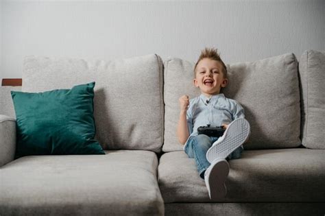 Niño feliz jugando videojuegos sosteniendo un controlador de juego