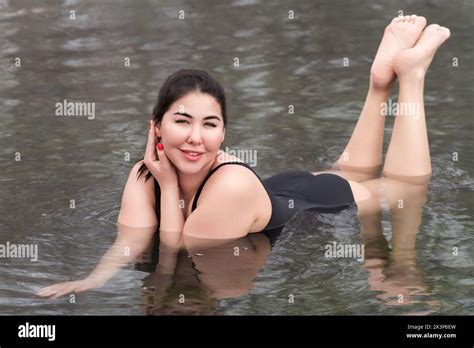 Happy Outsize Young Woman In Black One Piece Bathing Swimsuit Lying