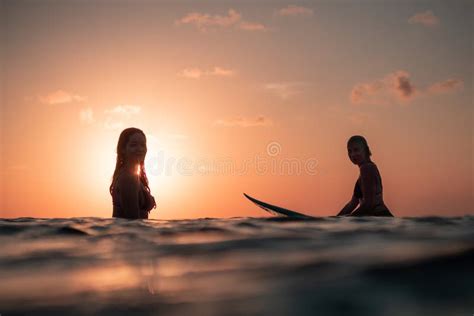 Portrait From The Water Of Two Surfer Girls With Beautiful Bodies On