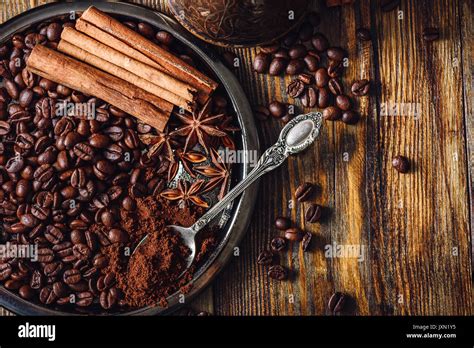 Coffee Beans With Spooonful Of Ground Coffee Cinnamon Sticks And