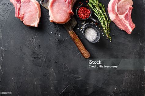 미국 의 고전적인 정육점 칼 또는 검은 슬레이트 테이블 상단에 향신료와 로즈마리와 고추와 칼 위에 설정 유기농 돼지 고기 갈비 하단에 텍스트를 위한 공간 0명에 대한 스톡
