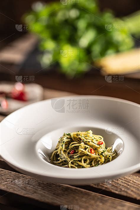 橄榄油大蒜罗勒西红柿和辣椒的意大利面盛在一个深盘子里