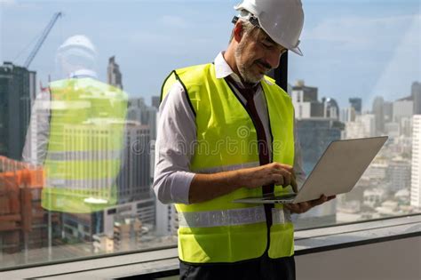 Close Up View Of Male Engineer With Safety Vest Holding Computer Laptop