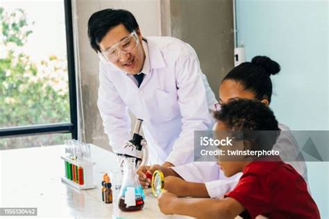 플라스 크를 들고 있는 젊은 과학자와 화학 실험실 실험에서 두 아프리카계 미국인 혼합 아이 들을 가르치고 교실에 대한 스톡 사진 및 기타 이미지 Istock
