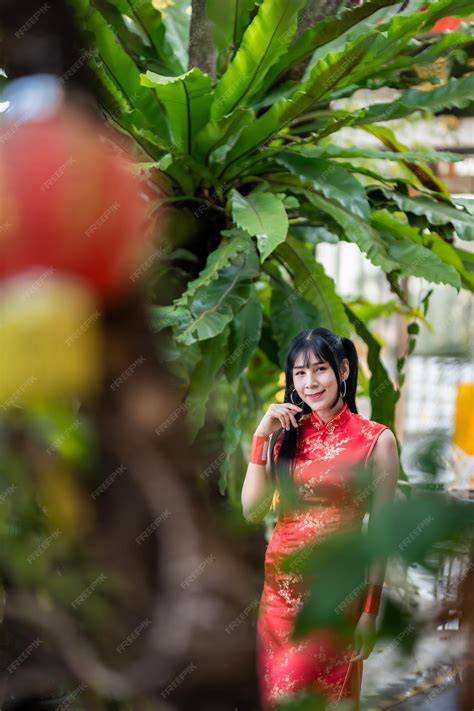태국의 공공 장소에서 중국의 문화를 축하하는 중국의 새해 축제를 위해 붉은 치파오 드레스 전통 장식을 입은 아시아 트랜스젠더