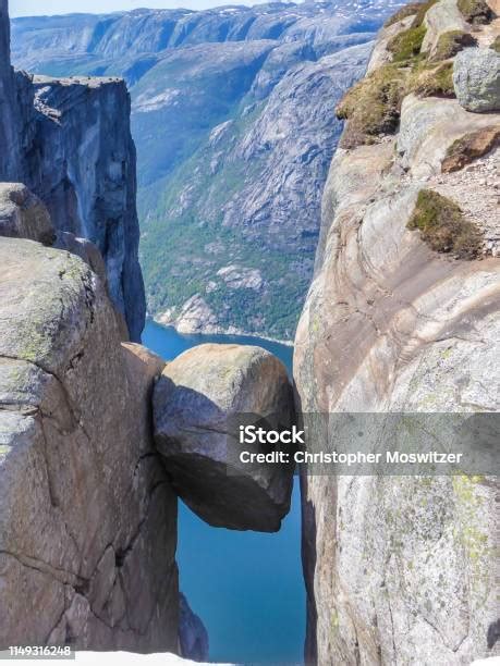 감히 악마 바위 Kjerag 노르웨이 공 모양의 바위는 1000m의 자유 낙하와 함께 두 개의 가파른 돌 벽 사이에 매달려 있습니다 그 뒤에는 Lysefjorden 있습니다