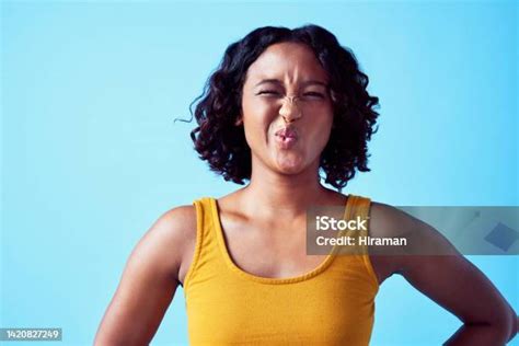 스튜디오 블루 배경에 그녀의 얼굴에 코믹 코와 입술 표정을 가진 재미있는 이모티콘 소녀 유머 화려하고 인간적인 초상화를위한 냄새 Ew 또는 미친 얼굴을 가진 코미디 젊고