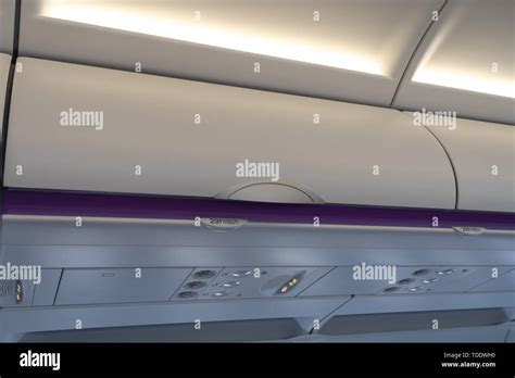 Carry On Luggage In Overhead Storage Compartment On Commercial Airplane