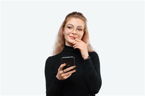 스마트 폰을 들고 캐주얼 한 옷을 입은 사려 깊은 젊은 아름다운 여성의 이미지 흰색 배경 20 24세에 대한 스톡 사진 및 기타