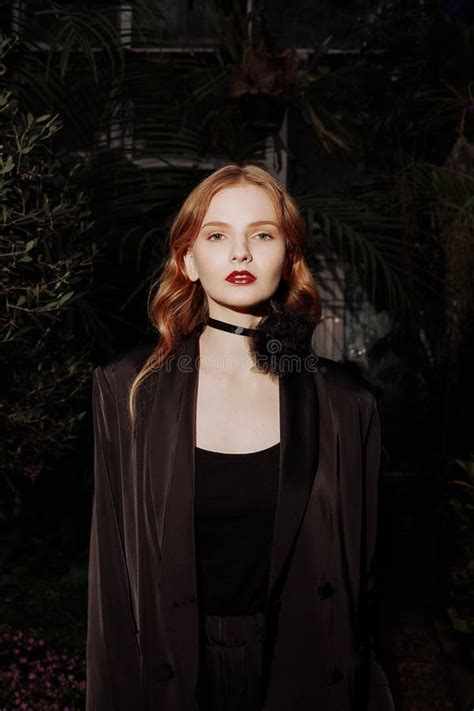 Female Model Illuminated By A Light Source Against A Background Of