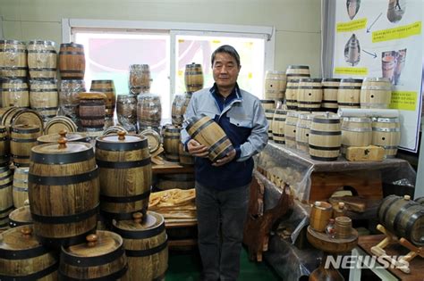오크통 들어 보이는 정충호 영동오크통 제작소 대표