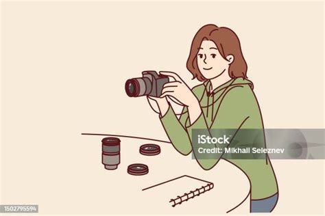 카메라를 든 여성 사진작가는 사진 에세이를 위해 렌즈를 선택하거나 초상화를 만드는 테이블에 앉아 있다 일러스트레이션에 대한 스톡