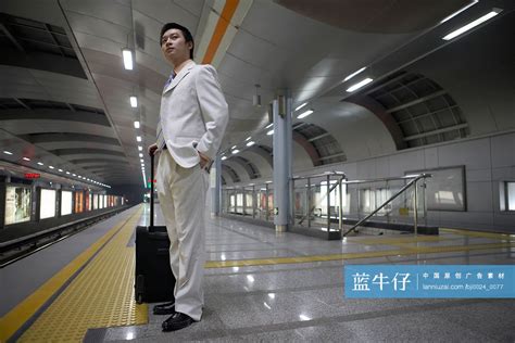 商务男士拖着行李箱等地铁 蓝牛仔影像 中国原创广告影像素材