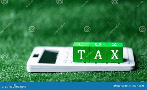 Wooden Cubes With Co2 Tax Word On Green Grass Background Concept Of