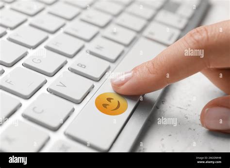 woman pressing key with happy emoticon on pc keyboard closeup stock