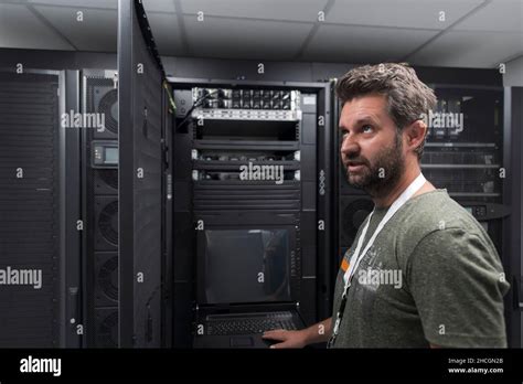 Data Center Engineer Usaing Keyboard On A Supercomputer Server Room