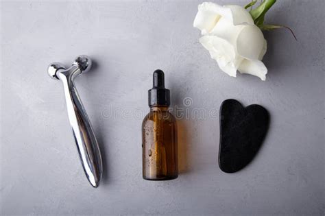 Luxurious Skincare Routine With A White Rose And Facial Tools On A Grey