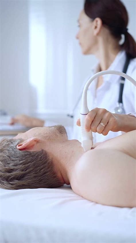 Doctor Woman Performing Neck Ultrasound Exam On Male Patient Medicine Service Concept Stock