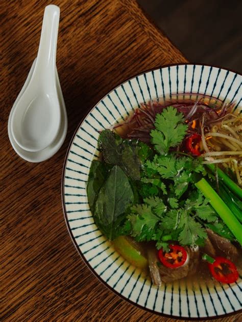 Flavorful 가정식 건강한 식사 고수 잎 국수 국수 그릇 길거리 음식 동남 아시아 레스토랑 맛있는 먹음직스러운 목조 테이블 미식가 발아 콩