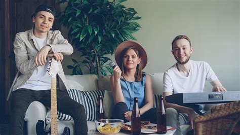 쾌활 한 젊은 이들이 전문 음악가 보컬 기타리스트와 악기를 들고 카메라를 보고 웃 고 Keyboarder의 초상화 금발 머리에