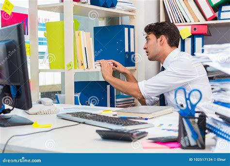 Businessman Working In The Office With Piles Of Books And Papers Stock