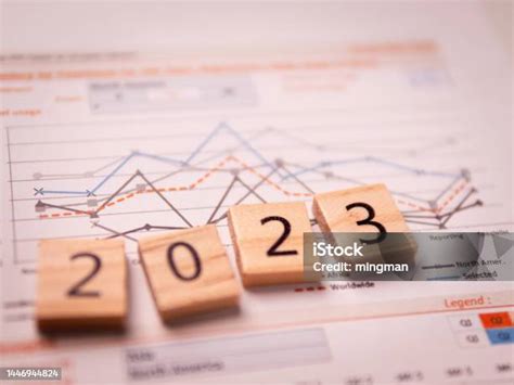 2023년 스프레드시트 데이터 분석 그래프와 사무실 개념의 차트에 대한 종이 보고서가 있는 나무 블록에 있는 텍스트 0명에 대한