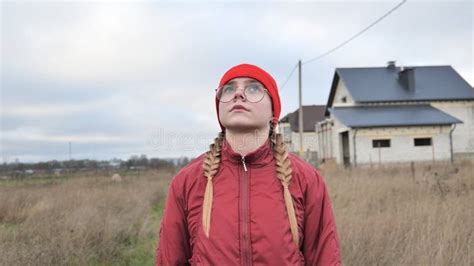 Portrait Of A Teenage Girl In Glasses Wearing Red Clothes Outside In