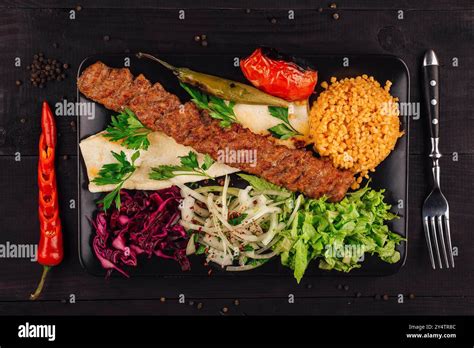 Traditional Turkish Adana Kebab Serving On A Plate With Grilled Tomato