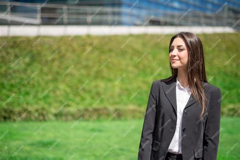 Mulher Jovem Sorridente Perto De Um Campo De Grama E Um Prédio De