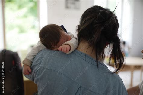 Mother Holding Sleeping Baby Over Her Shoulder Close Up Baby In White