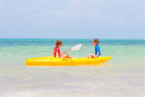 Little Adorable Girls Enjoying Kayaking On Yellow Kayak Stock Image