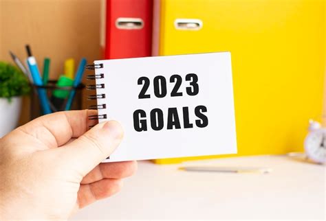 Premium Photo A Male Hand Holds A Notepad On A Spring With The Written 2023 Goals Text Office