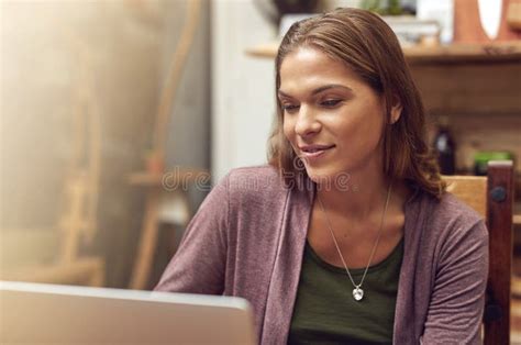 Expanding Her Customer Base With An Online Marketing Campaign A Young Woman Using A Laptop In A