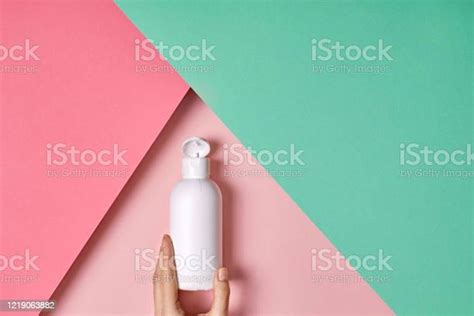 색상 배경 테이블에 고립 된 여자의 젊은 손 흰색 튜브 를 들고 보여주는 모의 텍스트 로고 브랜드에 대한 빈 장소 수평 아름다움