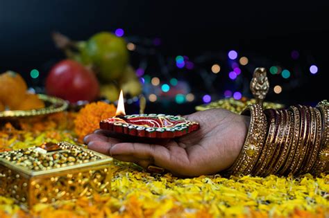 디왈리 푸자 새해 디파왈리 또는 슈브 디파발리 나브라트라 푸자 축제 축하에 대한 조명 클레이 디야 깊은 꽃 침대 장식과 보케