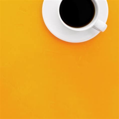 木製の黄色の背景にコーヒーカップの上から見た画像 無料の写真