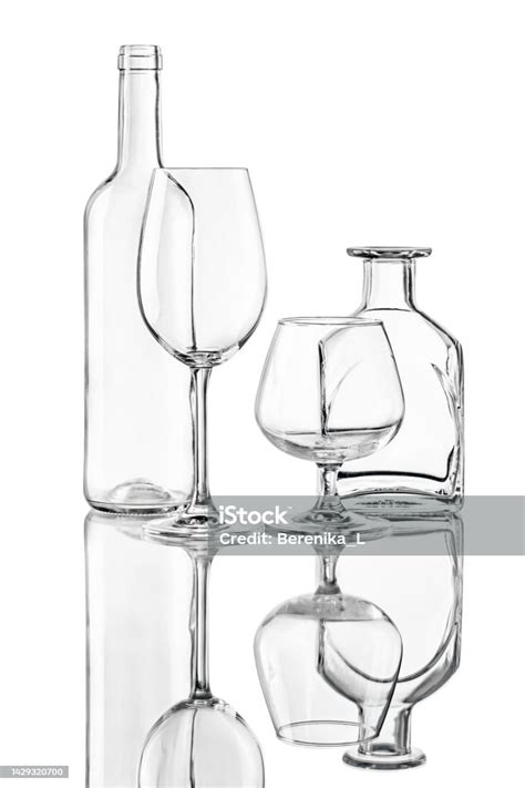 빈 맑은 와인과 코냑 병과 투명한 안경으로 개념적 정물화 스튜디오 샷은 흰색 배경에 고립 된 자연스러운 반사를 휘젓습니다 유리잔에 대한 스톡 사진 및 기타 이미지 Istock