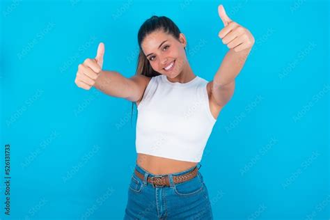 Beautiful Brunette Woman Wearing White Tank Top Over Blue Background
