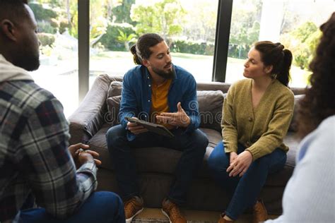 Diverse Group Of Friends And Male Therapist With Tablet In Group