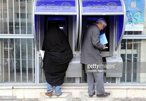 Iranians Withdraw Money From An Atm Machine In Front Of A Bank In