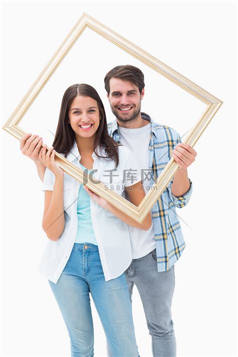拿着画框的愉快的年轻夫妇高清摄影大图 千库网