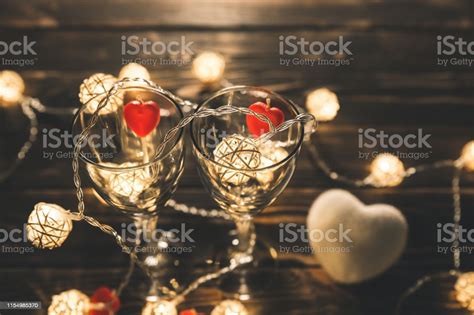 발렌타인 데이를 위한 하트와 로맨틱 한 와인 잔 낭만적 인 날짜와 저녁 식사 아늑한 조명 나무 배경입니다 휴일 엽서 사랑