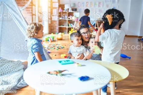아름다운 교사와 유아의 그룹은 유치원에서 장난감의 많은 주위에 재생 가정 생활에 대한 스톡 사진 및 기타 이미지 가정 생활 가정의 방 개발 Istock